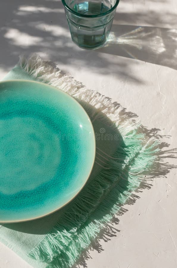 Empty Turquoise Ceramic Plate with Napkin with Fringe on White Plaster ...