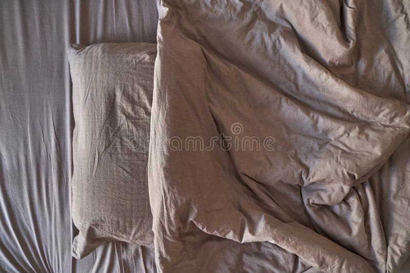 Empty Unmade Bed with Wrinkled Sheets and Pillow in Neutral Tones ...
