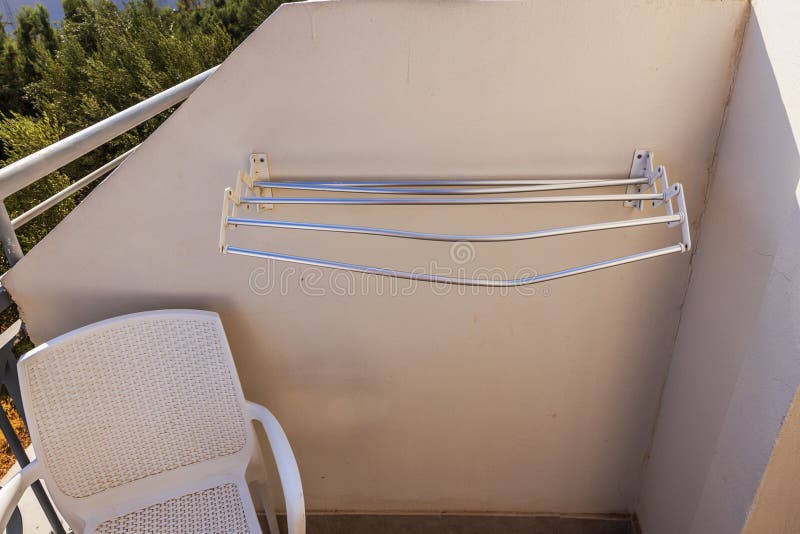 Empty Wall-mounted Drying Rack on Sunny Balcony with White Plastic ...