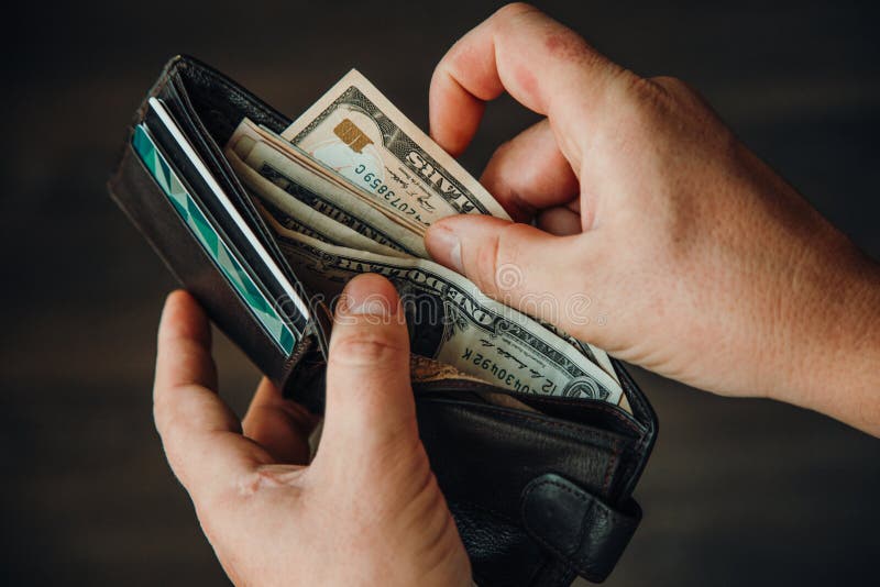 An Empty Wallet with a Small Amount of Money in the Hands of a Working ...