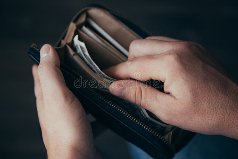 An Empty Wallet with a Small Amount of Money in the Hands of a Working ...