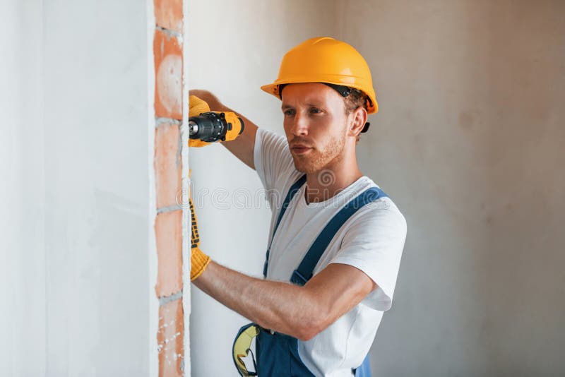Empty Walls. Young Man Working in Uniform at Construction at Daytime ...