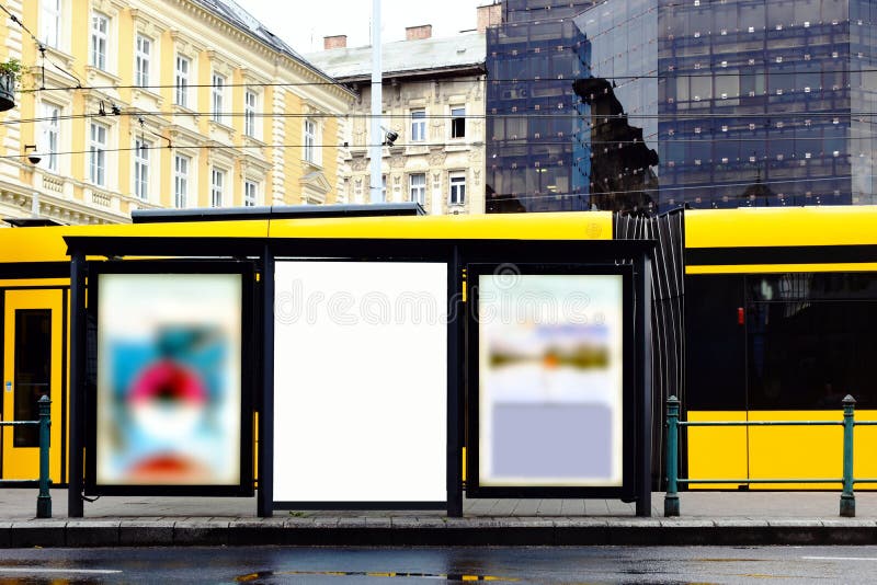 Empty White Ad Panel and Light Box at a Tram Stop with Urban Background ...