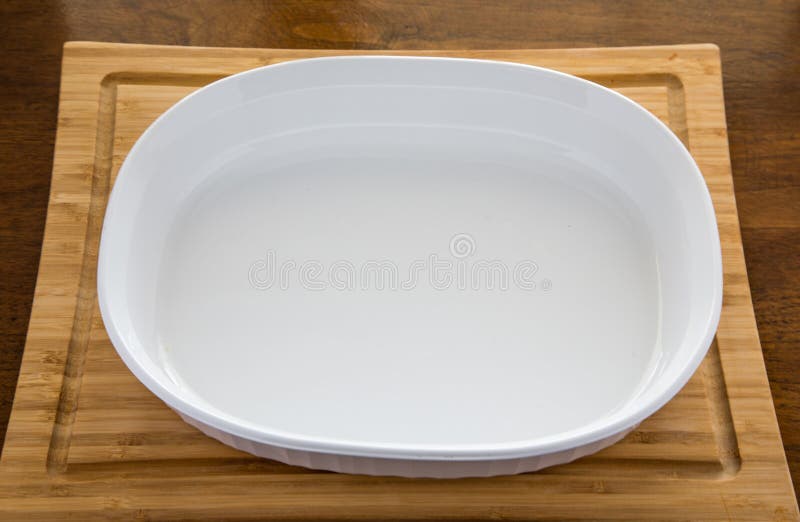 Empty White Casserole Dish on Wood Cutting Board Stock Photo - Image of ...