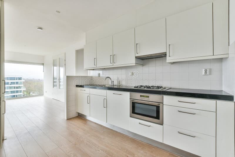 Empty White Kitchen with Laminate Flooring and Closets Stock Photo ...