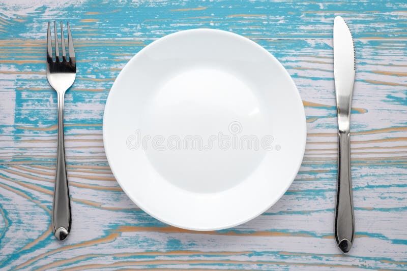 Empty White Plate with Silver Fork and Knife on Blue Wooden Table ...