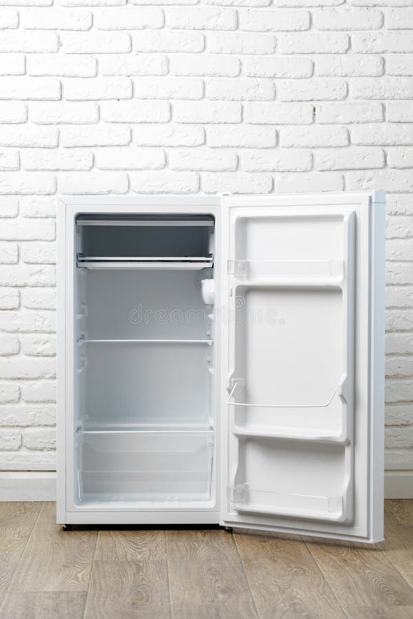 Empty White Refrigerator with Open Door in Front of White Brick Wall ...