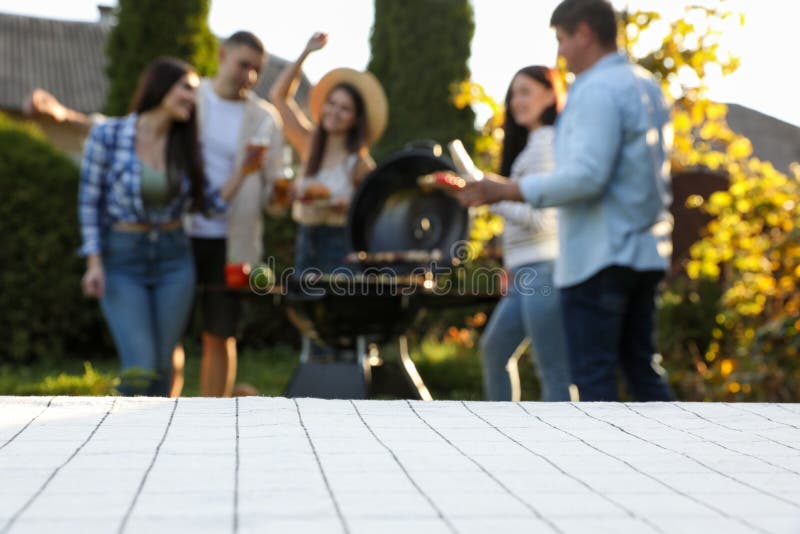Empty White Wooden Table and Blurred View of Friends Having Barbecue ...