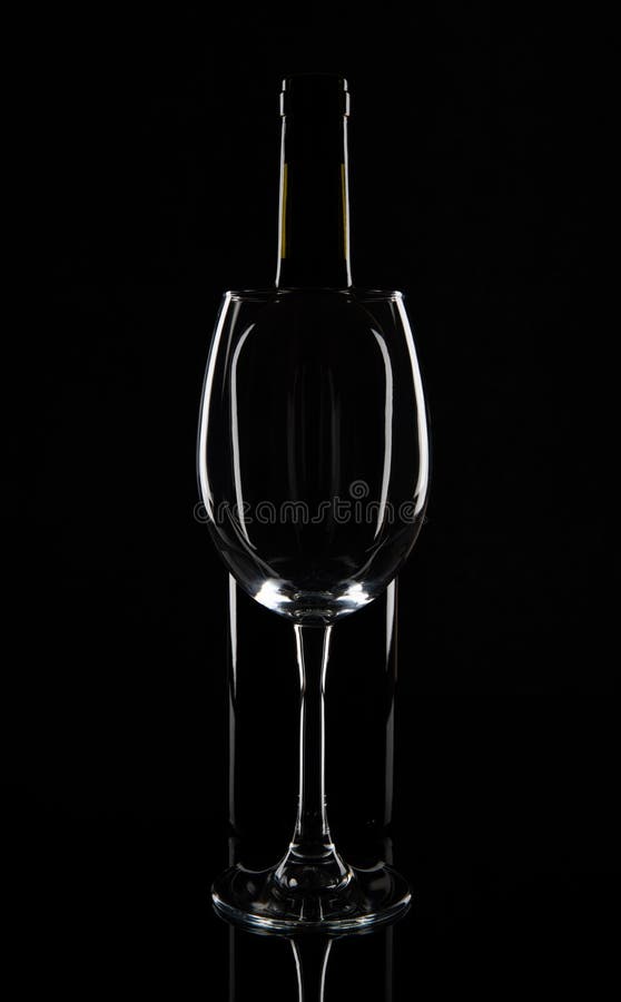 Empty Wine Glass in Front of the Wine Bottle, Isolated on Black ...