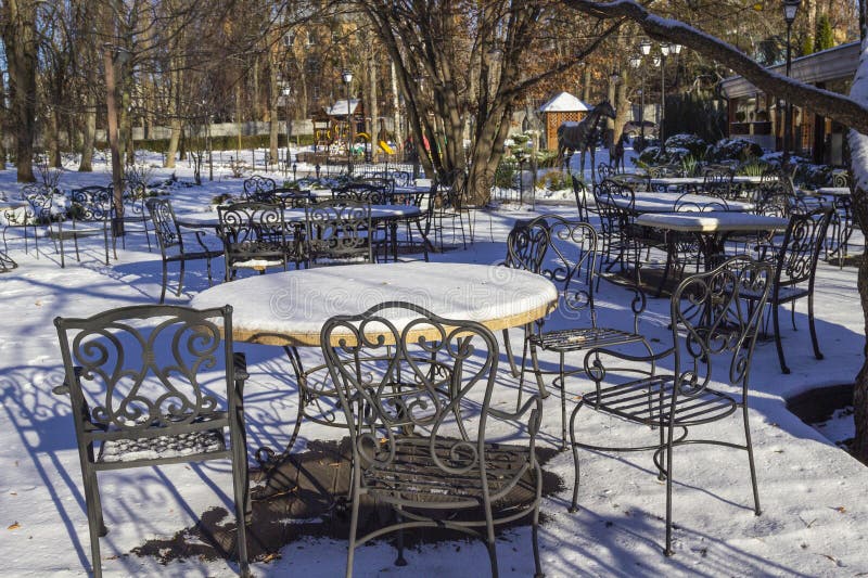 Empty Winter Cafe Terrace. Round Tables with Snow and Patterned Metal ...