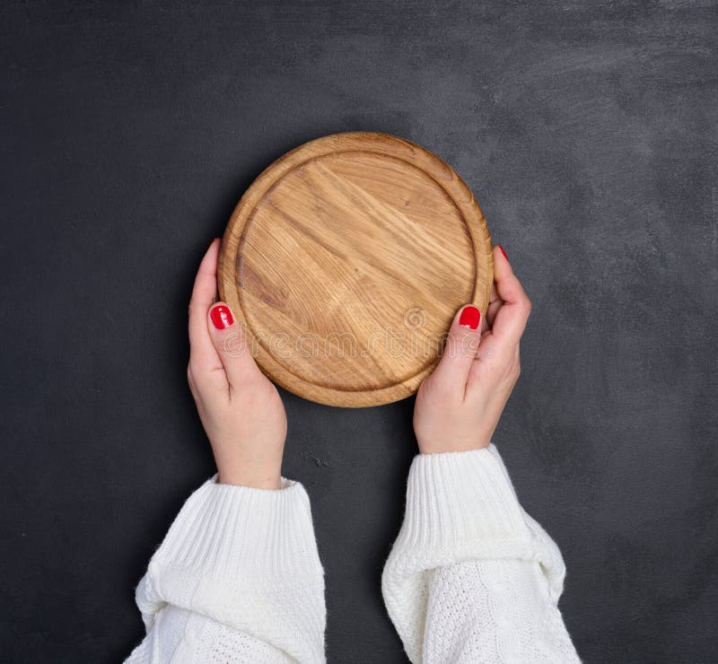 Empty Wooden Cutting Board in Female Hands on Black Wooden Table, Top ...