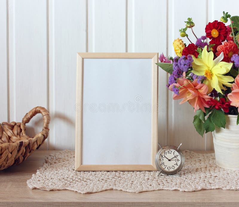 Empty Wooden Frame on a Table with Flowers and a Metal Clock Stock ...