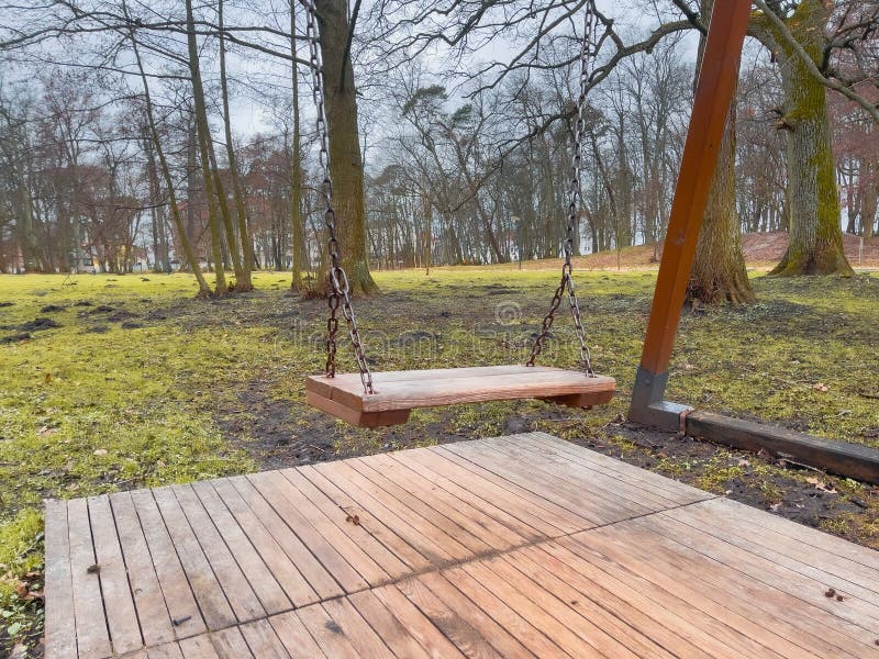Empty Wooden Swing Hanging in a Tranquil Park during a Cloudy Day with ...
