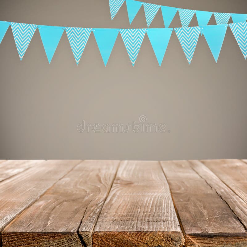 Empty Wooden Table and Decorative Bunting Flags Hanging on Beige Wall ...