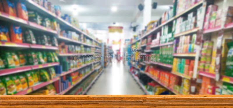 Empty Wooden Table in Front of a Grocery Store with Rows of Shelves ...