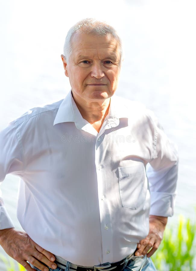 En Mogen Positiv Man över 60 år Med Grått Hår I En Vit Skjorta Går I