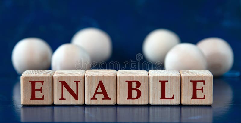 ENABLE - Word on Wooden Cubes on a Blue Background with Wooden Balls ...