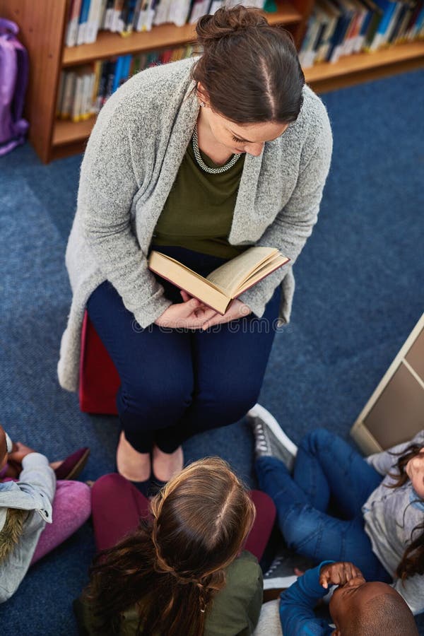 Encouraging Their Curious Minds. a Teacher Reading To a Group of ...