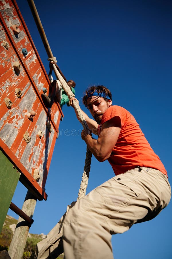 Endure and Conquer. a Young Man Climbing Over an Obstacle at Military ...