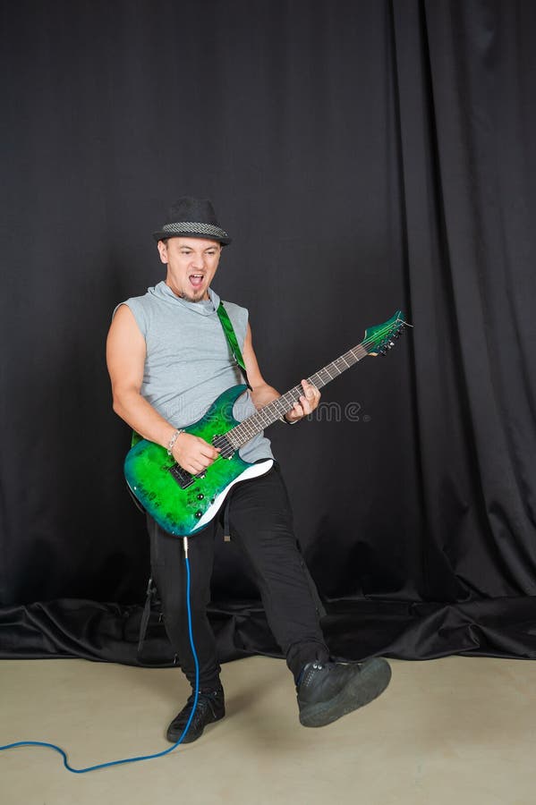 Energetic Guitarist Performing with a Electric Guitar in a Dynamic Pose ...