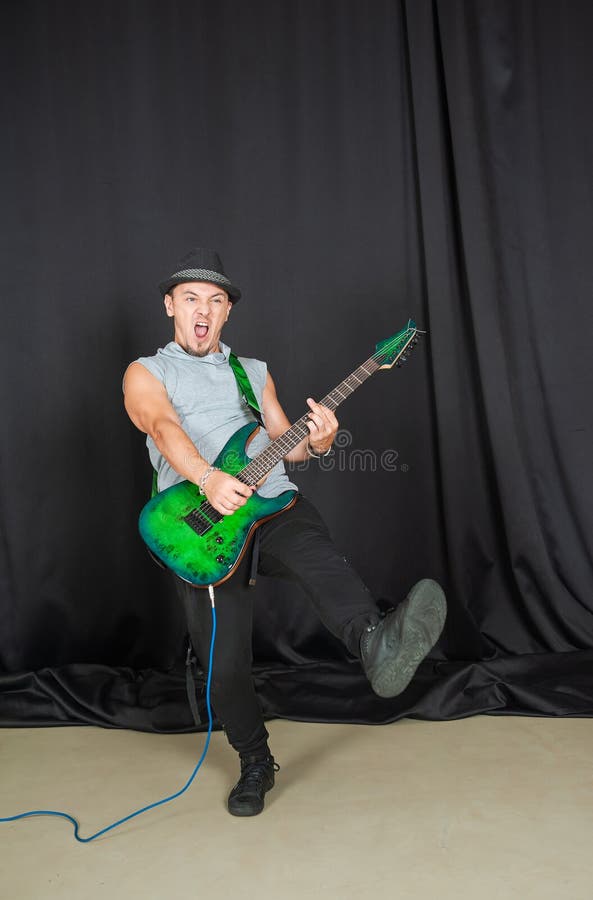 Energetic Guitarist Performing with a Electric Guitar in a Dynamic Pose ...