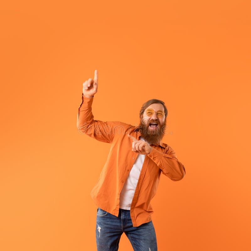 Energetic Redhaired Man Pointing Upward with Joy while Dancing, Studio ...
