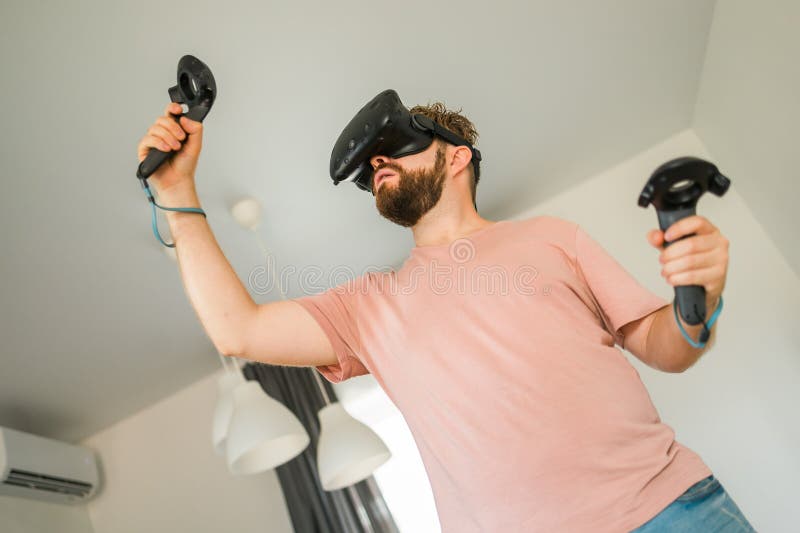 Energetic Young Man Wearing Virtual Reality Headset and Holding ...