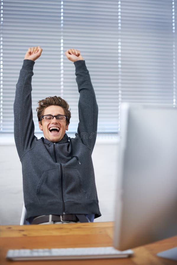 Energized by His Success. a Handsome Young Man Celebrating at His Desk ...