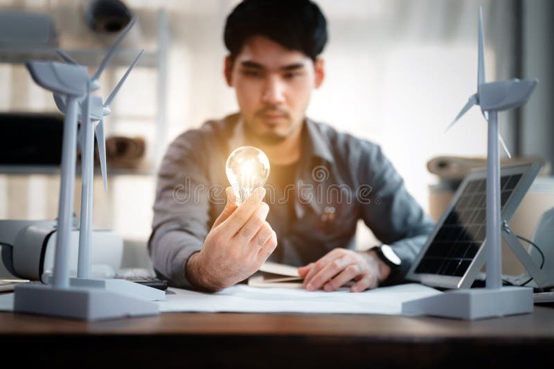Energy Engineer Holding Light Bulb in Modern Office with Solar Cell ...
