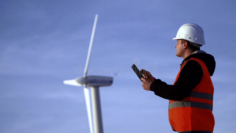 Energy Engineer of the Windmill To Work with the Tablet at Sunset ...