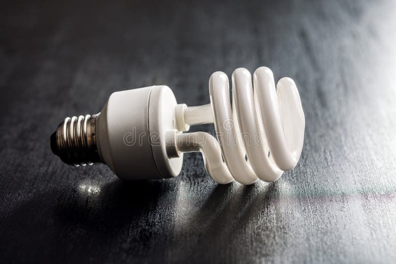 Energy Saving Light Bulb on Black Table. Fluorescent Lightbulb Stock ...