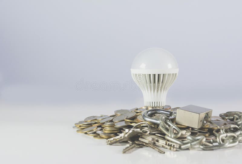 Energy Saving Light Bulb with Lock Surrounding by Stacks of Coin Stock ...