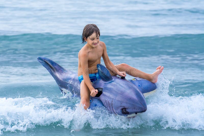 Enfant Jouant Avec Le Requin Gonflable Dans Les Vagues Photo stock ...