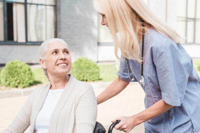 Enfermeira Que Olha a Mulher Deficiente De Sorriso Foto de Stock ...