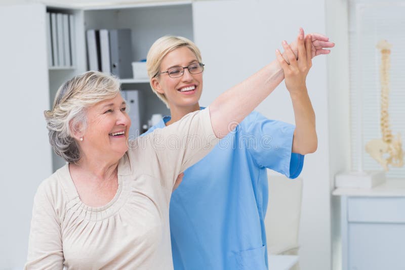 Enfermera Que Ayuda Al Paciente Mayor En El Ejercicio Imagen de archivo ...