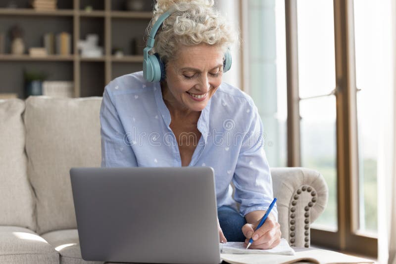 Elderly Lady in Headset Watching Webinar on Notebook Taking Notes Stock ...