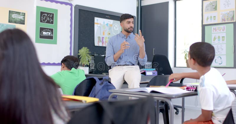 Engaged Teacher Explains a Lesson in a Bright School Classroom in ...