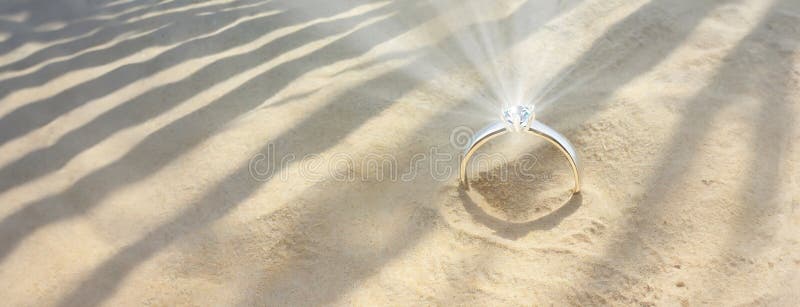 Engagement Ring Casting a Heart Shadow on the Sand. an Engagement Ring ...