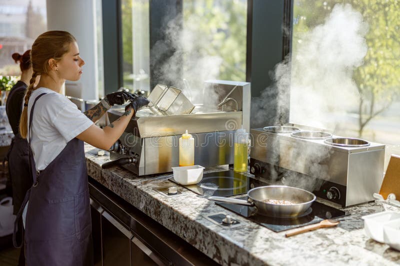 Engaging in Culinary Action within a Modern Kitchen that Involves Steam ...