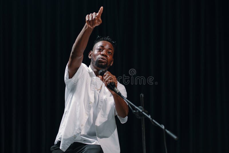 Engaging Performer Pointing while Holding Microphone Stock Photo ...