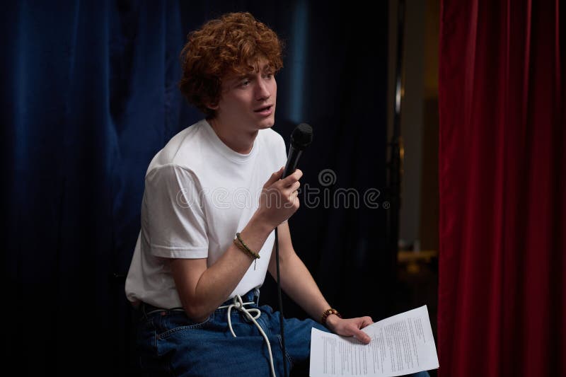 Engaging Singer Holding Microphone and Paper Notes Stock Photo - Image ...