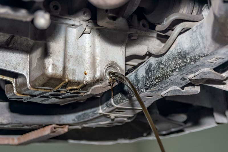 Engine Oil Flows Out of the Engine Reservoir in a Stream into a Bucket ...