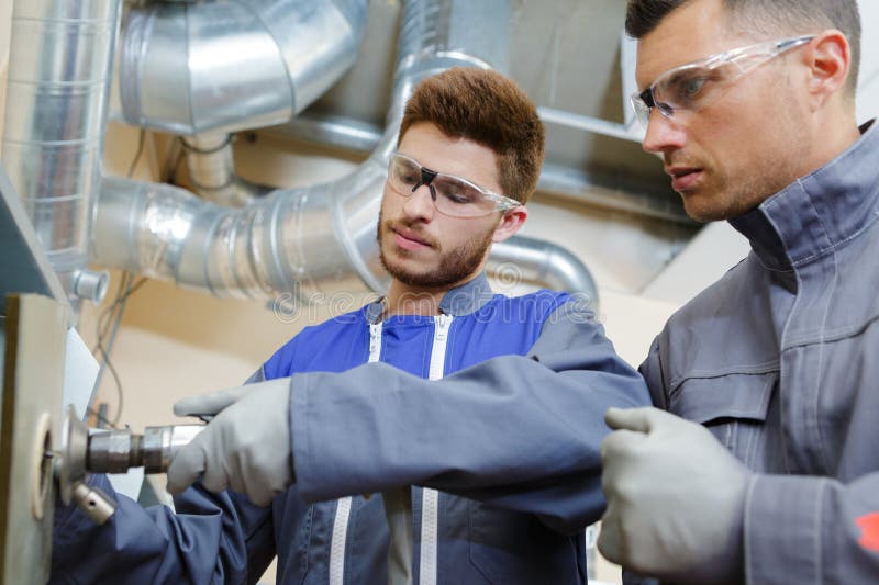 Engineer Advising Apprentice in Factory Front View Close Up Stock Photo ...