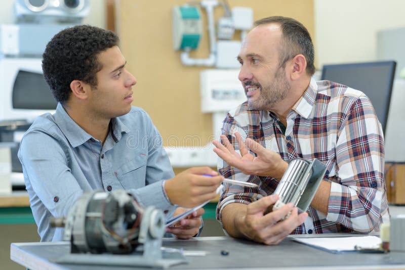 Engineer and Apprentice Examining Component in Office Stock Image ...