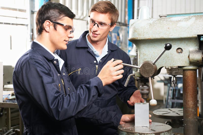 Engineer and Apprentice Using Machinery in Factory Stock Image - Image ...