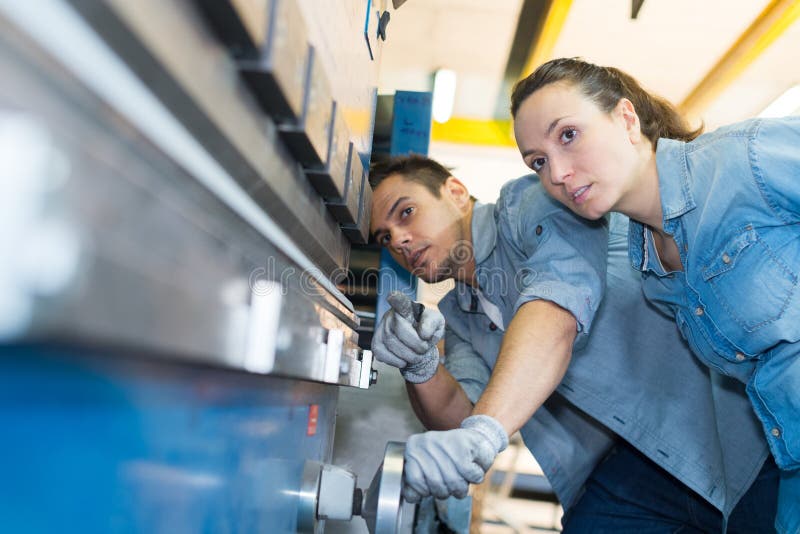 Engineer and Apprentice Working on Machine in Factory Stock Photo ...