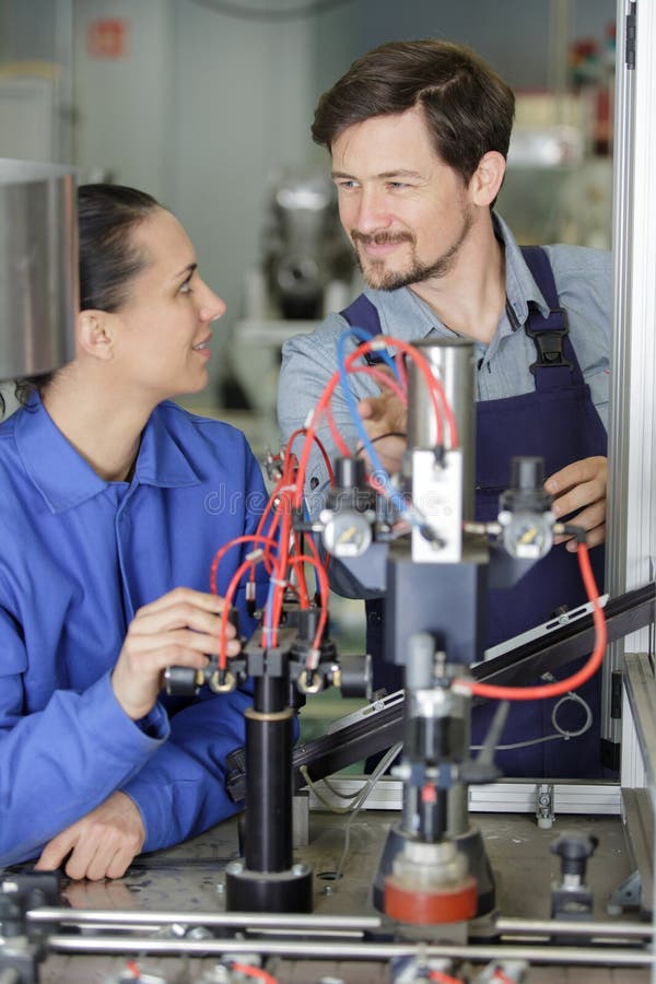 Engineer and Apprentice Working on Machine in Factory Stock Image ...
