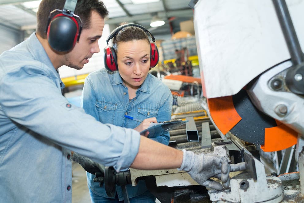 Engineer and Apprentice Working on Machine in Factory Stock Photo ...