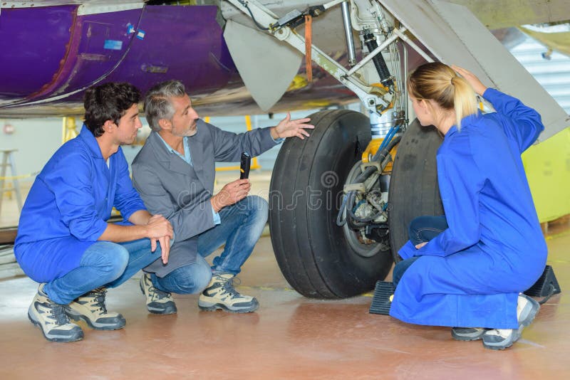 Engineer and Apprentices Checking Airplane Wheels Stock Image - Image ...
