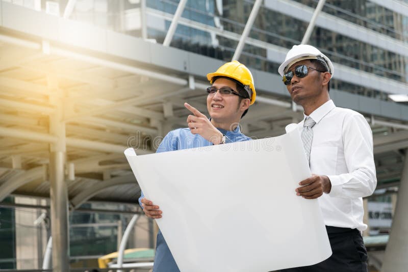 Engineer and Architect Working at Construction Site with Blueprint ...